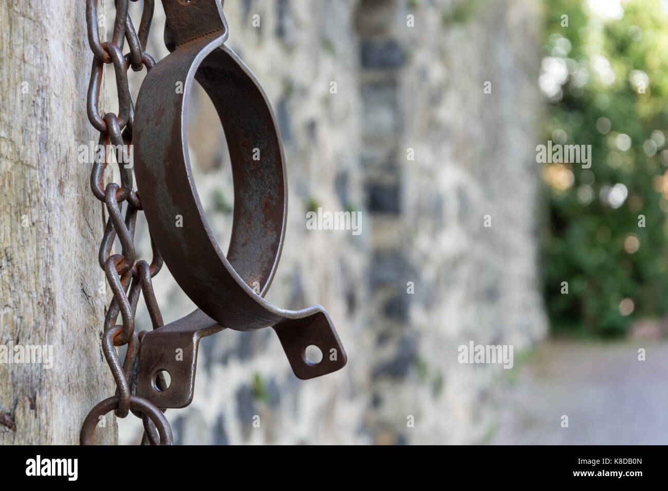 Medieval prison chains for prisoners in front of stone wall close up ...