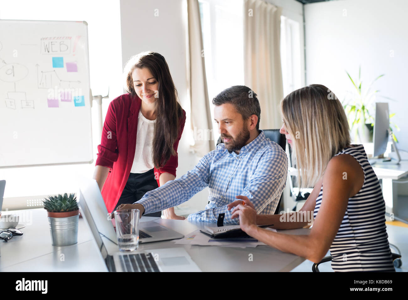 Three business people in the office talking together Stock Photo - Alamy