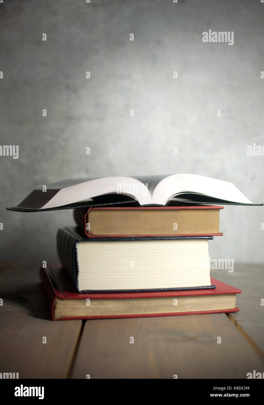 Open book on top of a stack with background space Stock Photo - Alamy