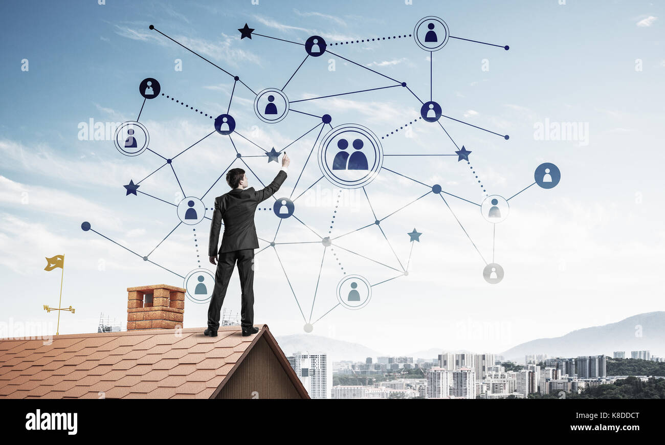 Businessman on house roof presenting networking and connection c Stock ...