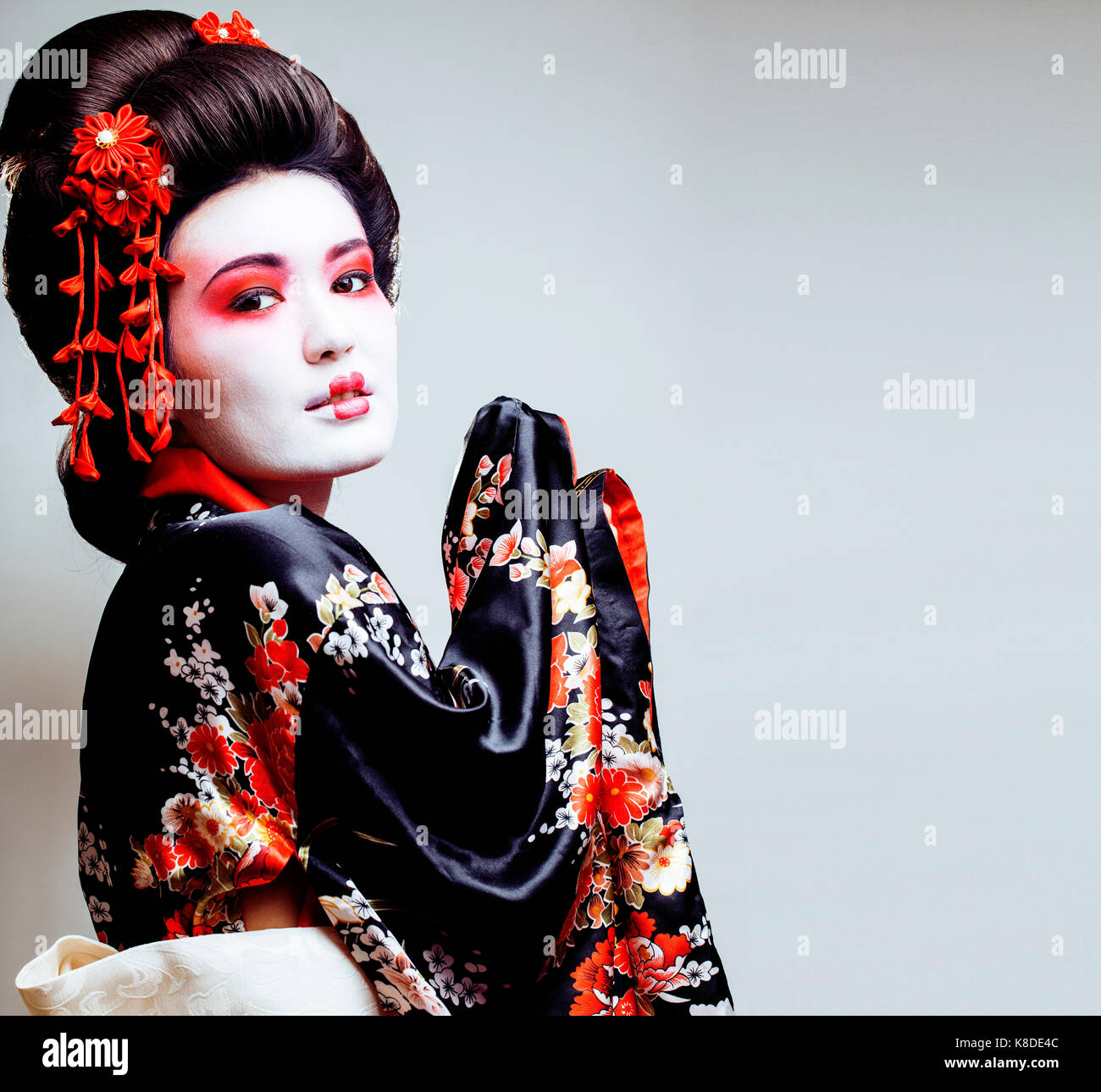 young pretty geisha in kimono with sakura and red decoration des Stock ...