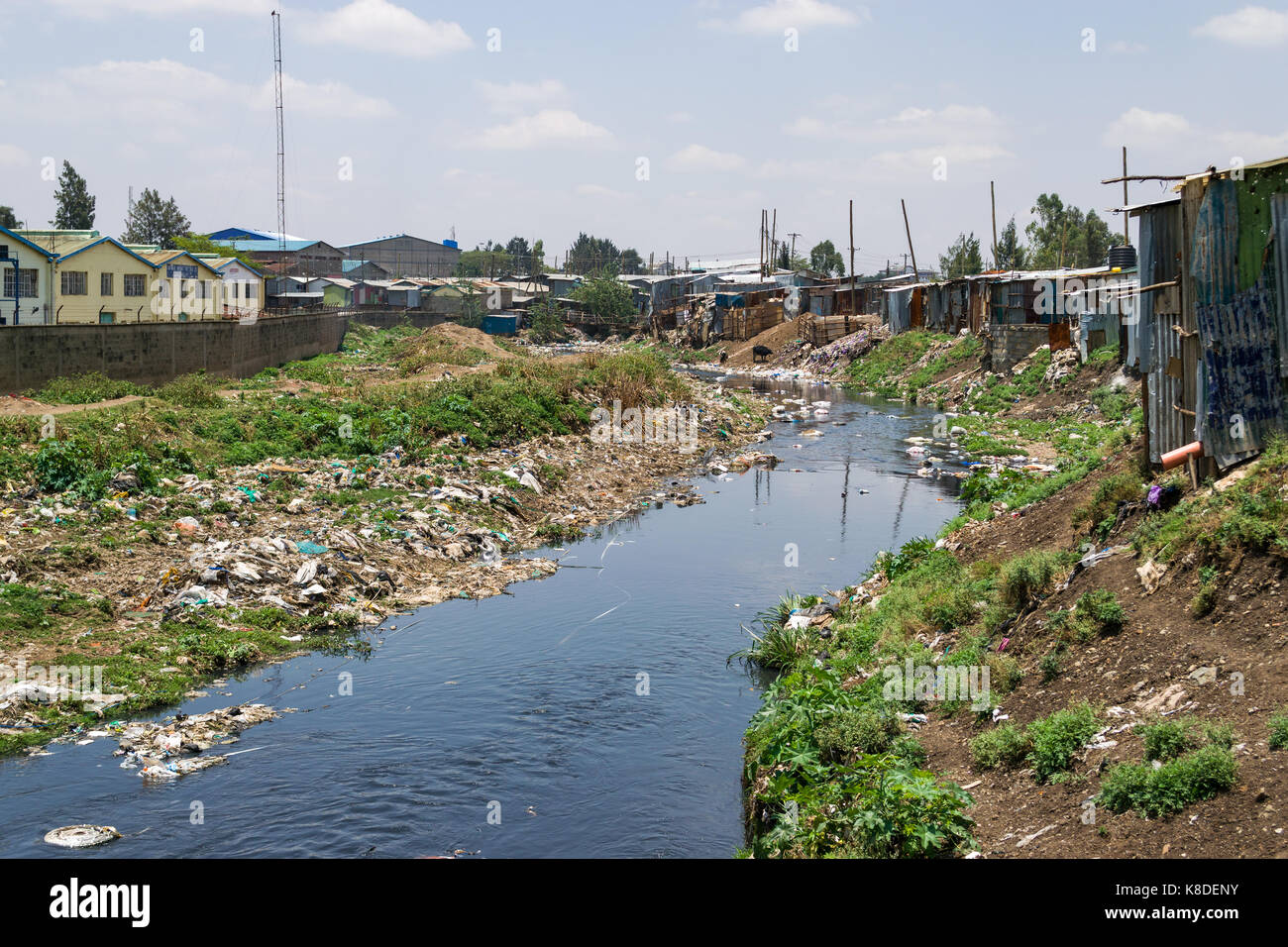 Slum shacks and buildings line the Ngong river which is polluted with ...