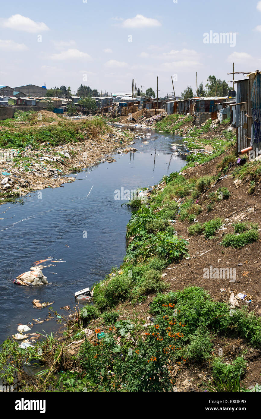 Slum shacks and buildings line the Ngong river which is polluted with ...