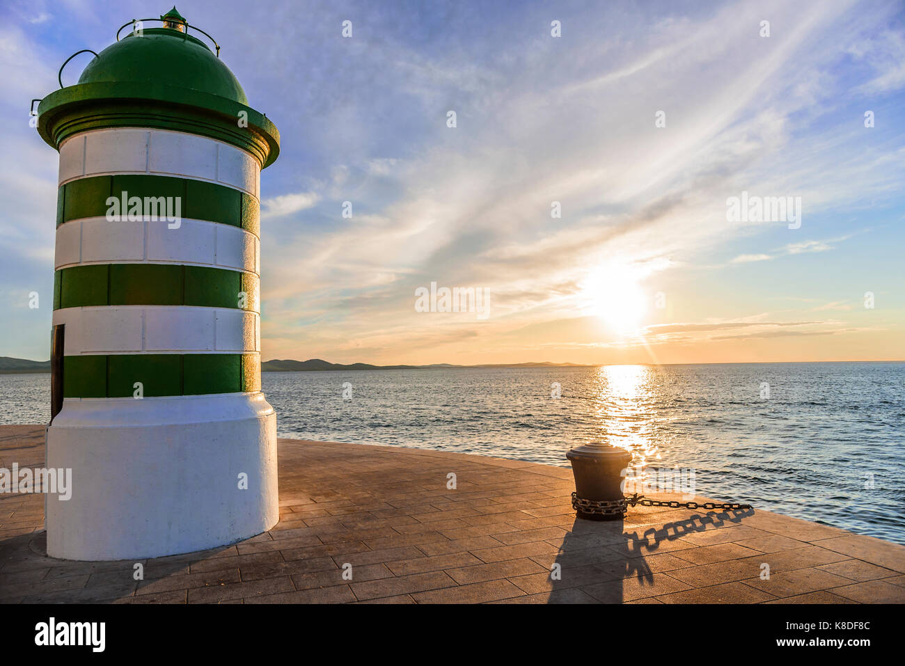 Green lighthouse at sunset Stock Photo - Alamy