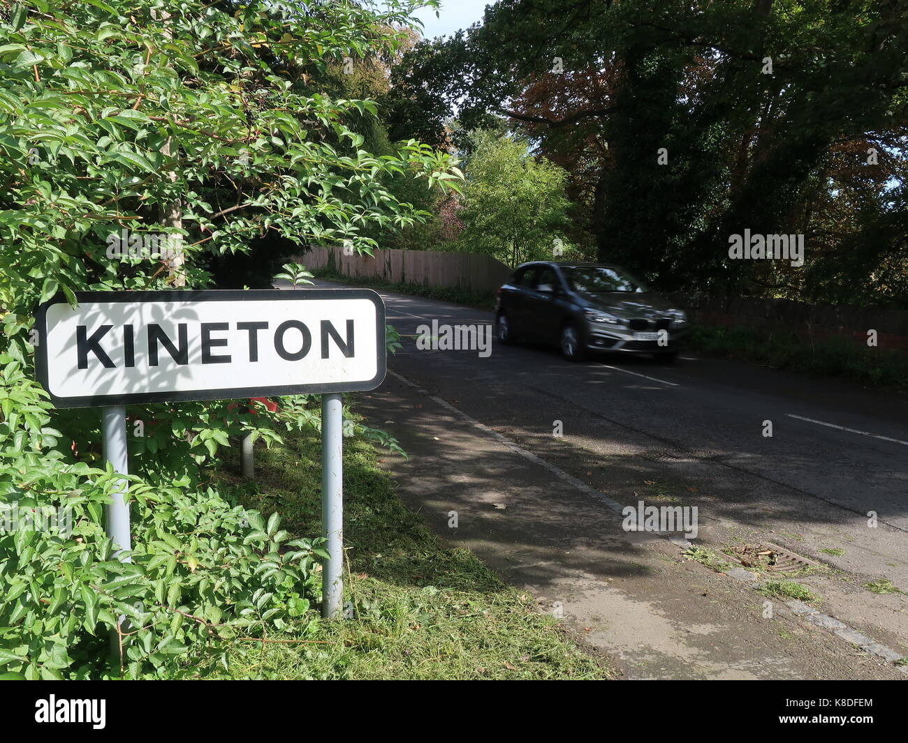 Kineton village sign and passing car. Warwickshire, UK Stock Photo - Alamy