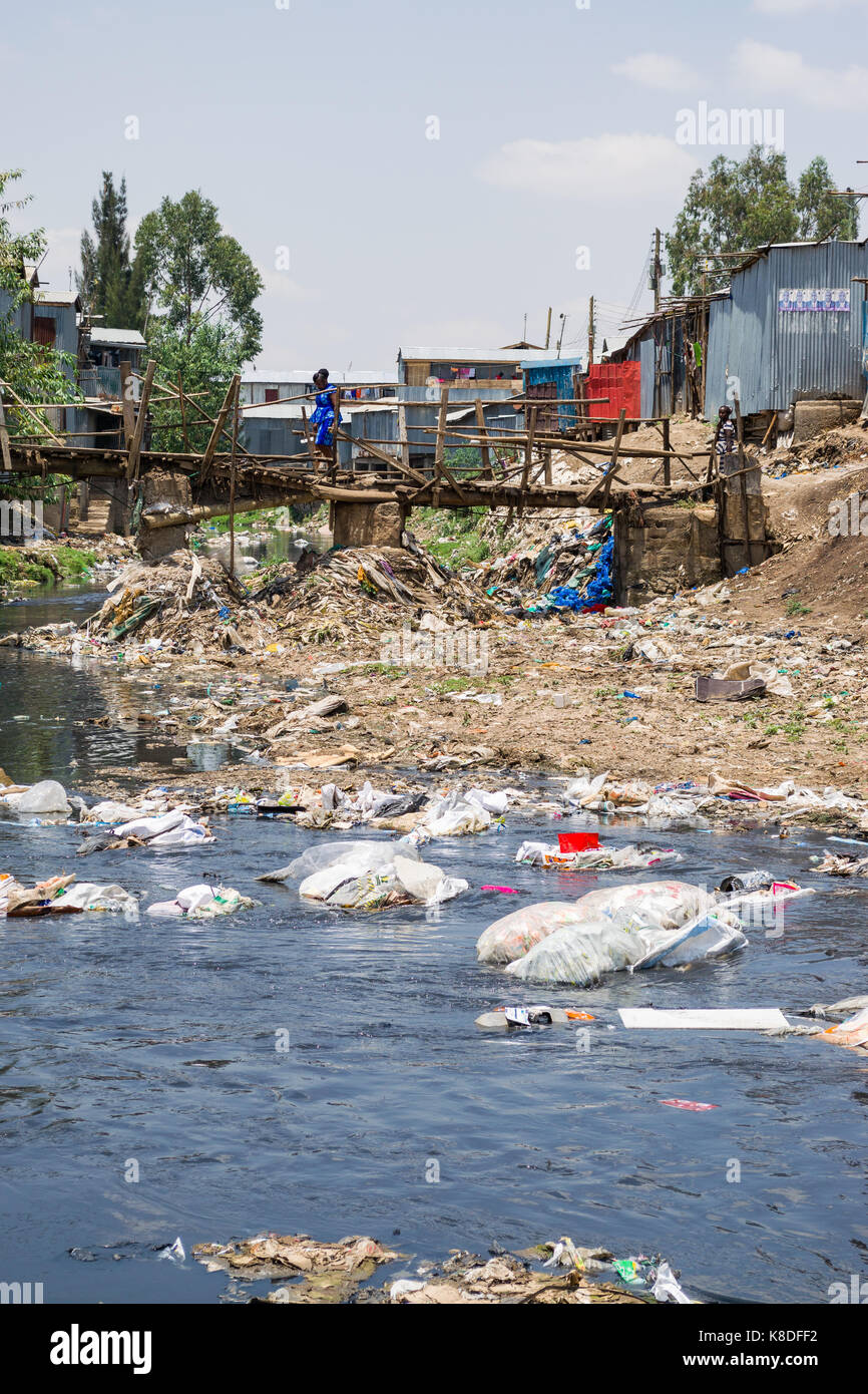 Slum shacks line the Ngong river which is polluted with rubbish ...