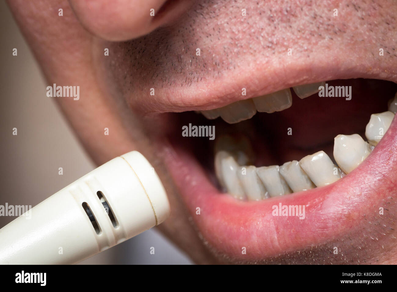 The lower part of the face close up of a man talking into a microphone ...