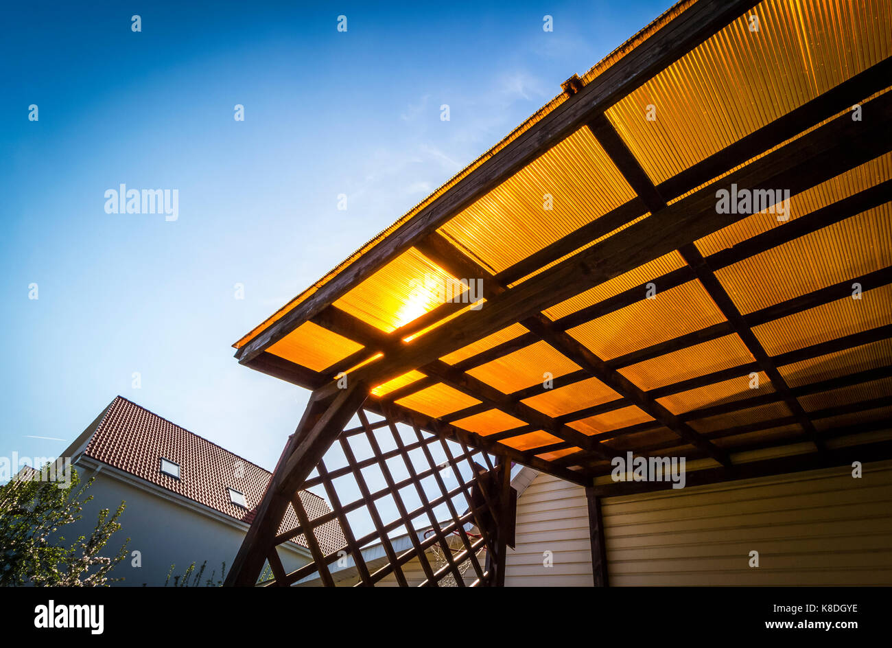 The roof of the veranda of orange polycarbonate on blue sky background ...