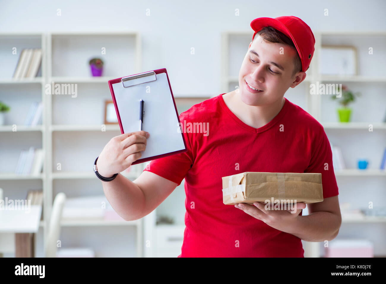 Post man delivering a parcel package Stock Photo - Alamy