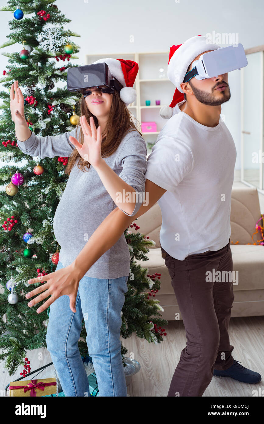Young family expecting child baby wearing virtual reality VR glasses ...