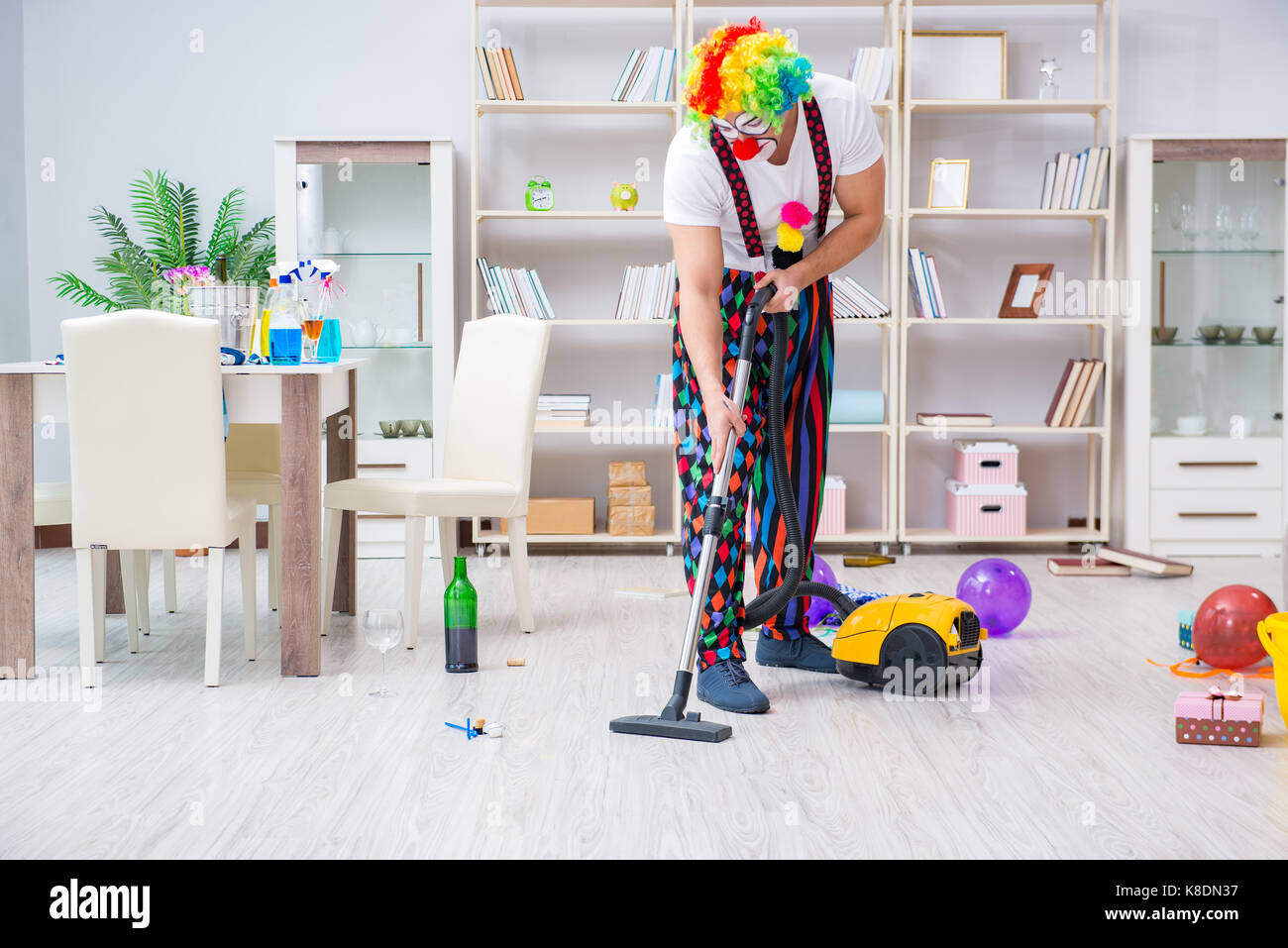 Funny clown doing cleaning at home Stock Photo - Alamy