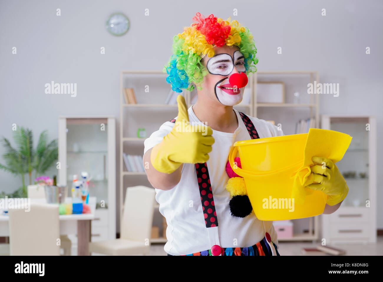 Funny clown doing cleaning at home Stock Photo - Alamy