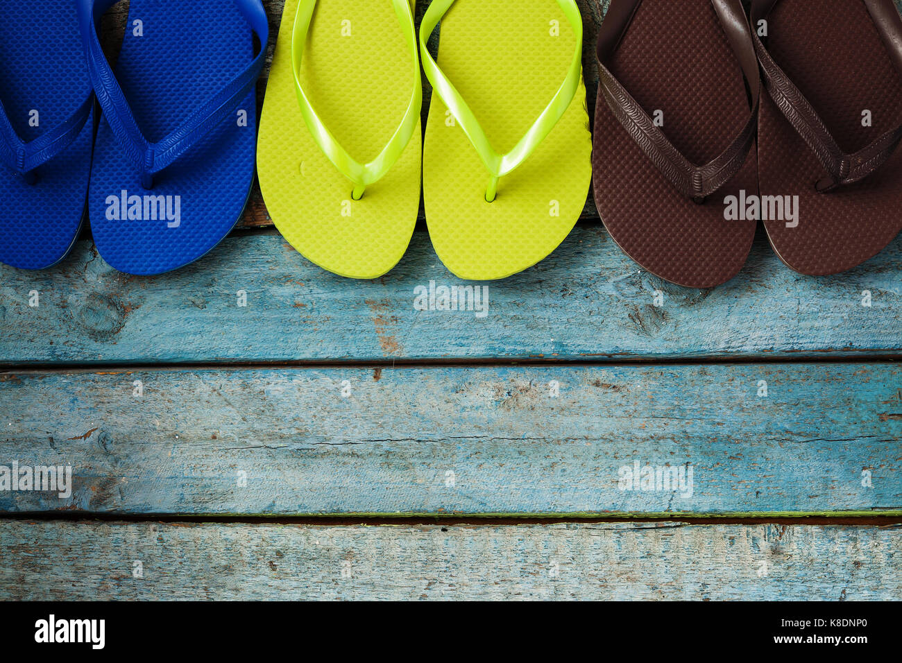 Several pairs of multi-colored rubber flip-flops exhibited in a row on ...