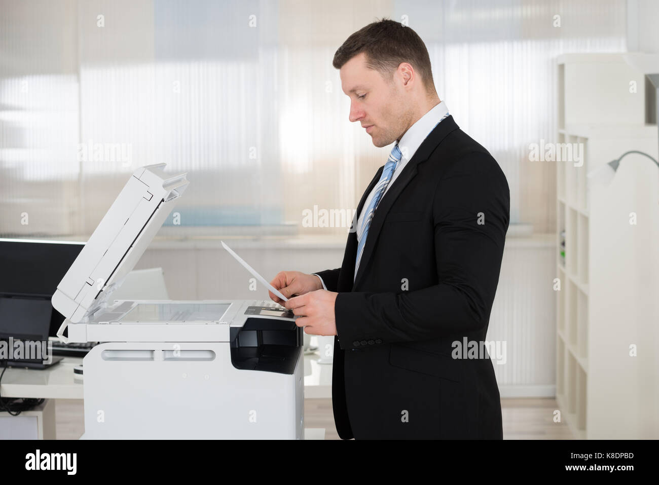 Side view portrait of businessman using photocopy machine in office ...