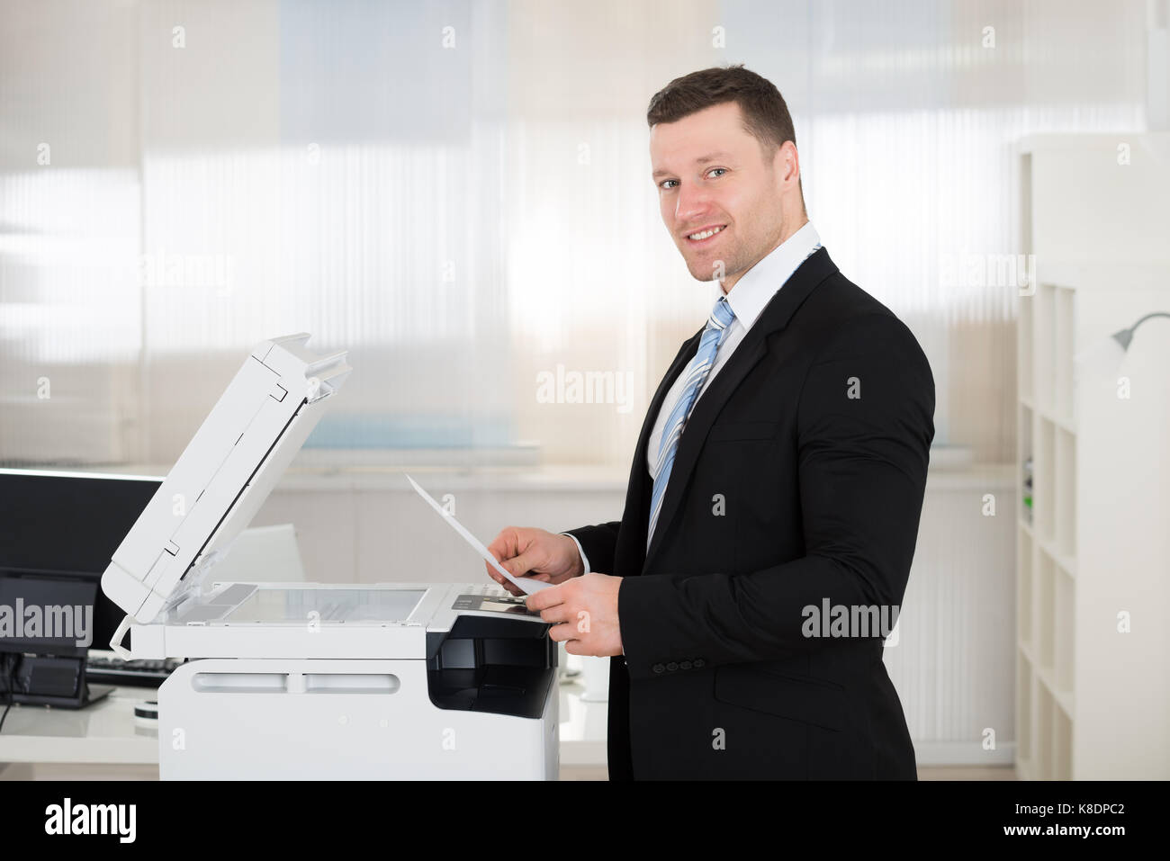 Side view portrait of businessman using photocopy machine in office ...