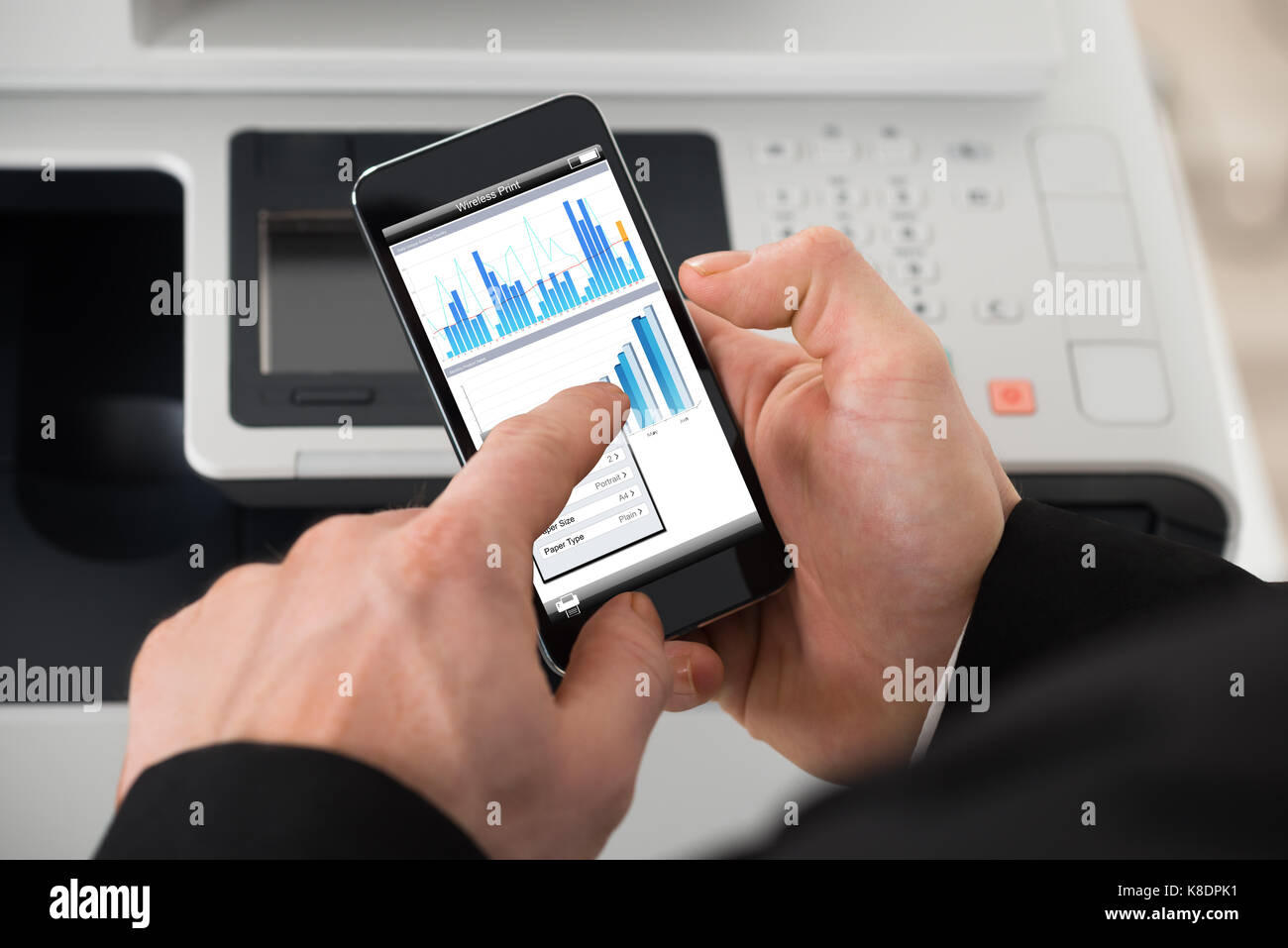 Cropped image of businessman giving print command on smart phone in ...