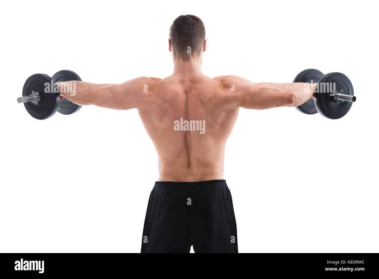 Rear view of muscular man lifting dumbbells against white background ...