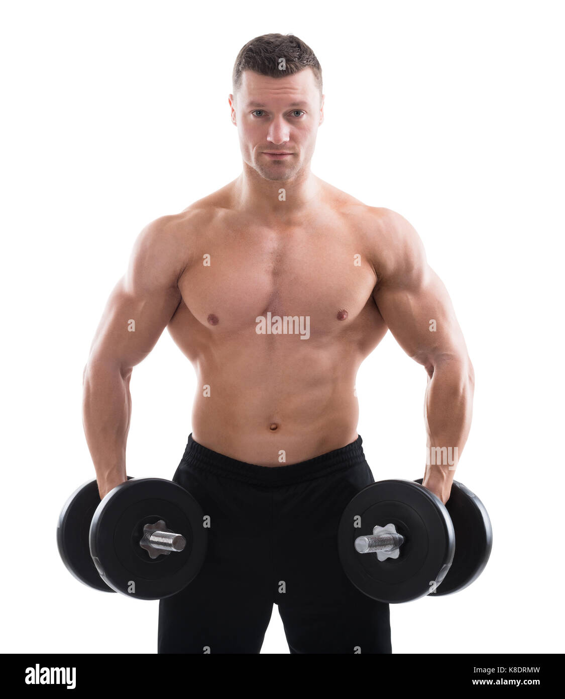 Portrait of confident muscular man lifting dumbbells while standing ...