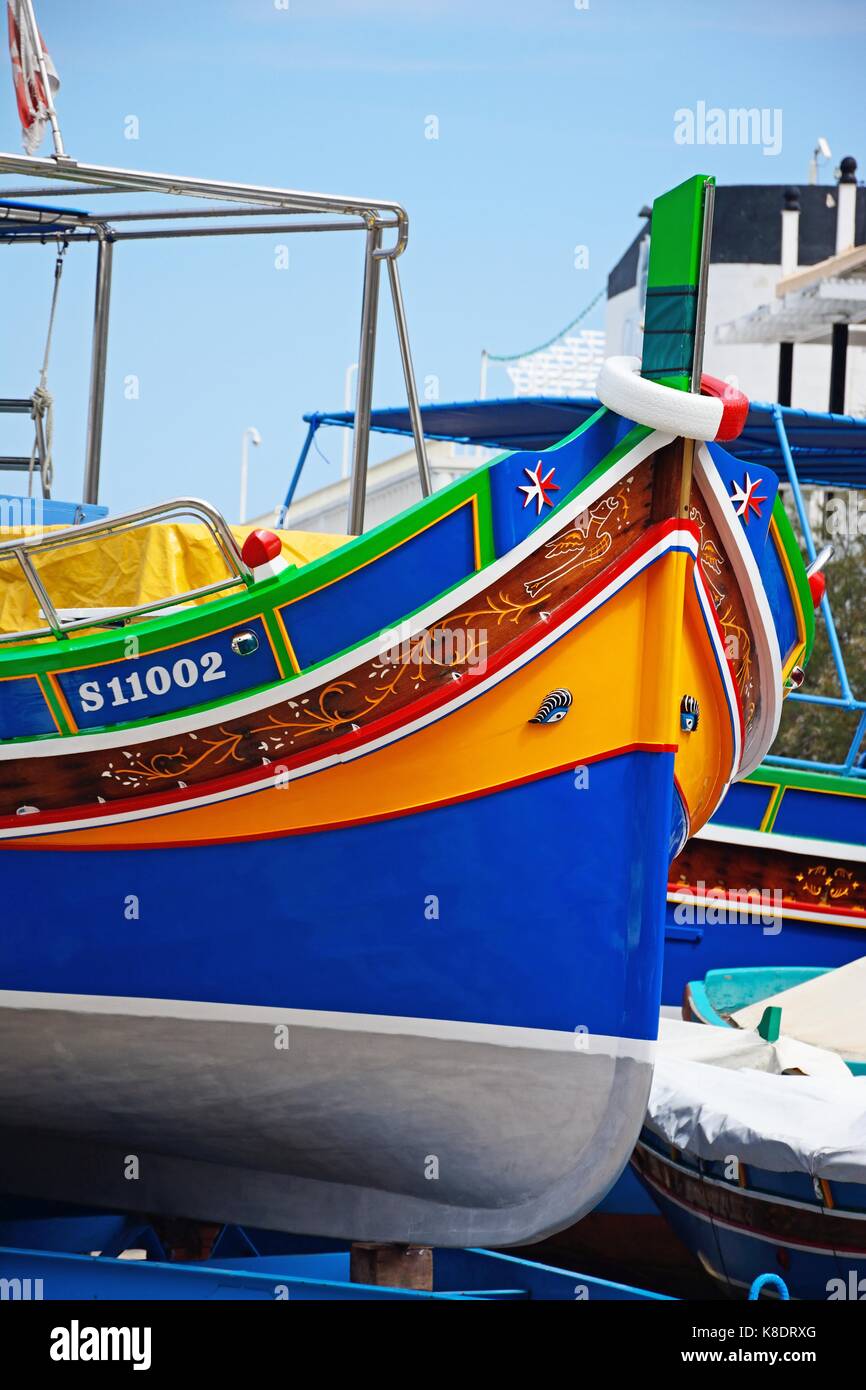 The bow of a brightly painted traditional Dghajsa boat in a boatyard ...