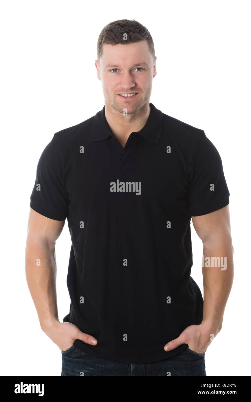 Handsome mid adult man in black tshirt standing with hands in pockets ...