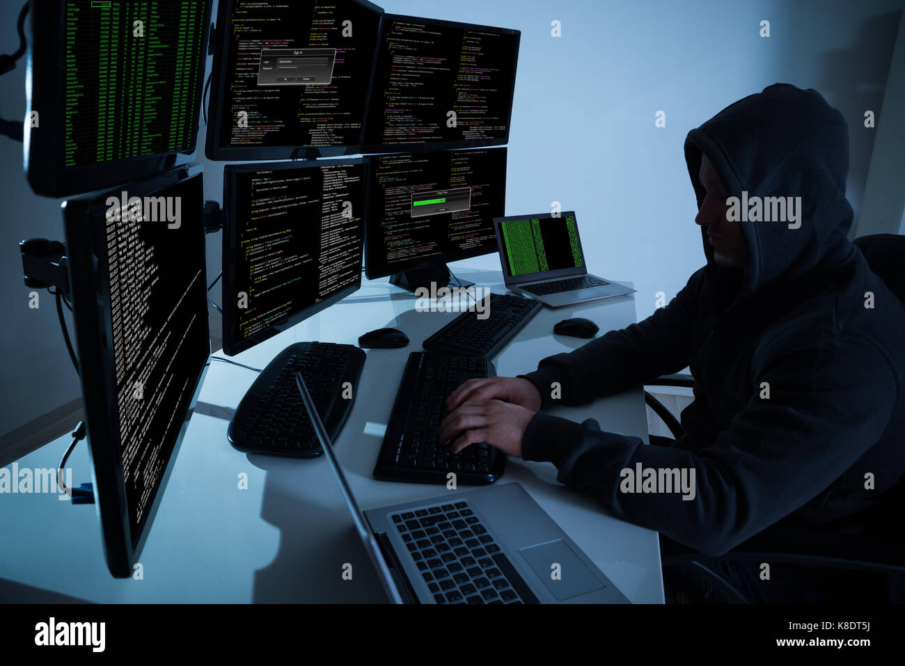 Rear view of hacker using computers to steal data in office Stock Photo ...