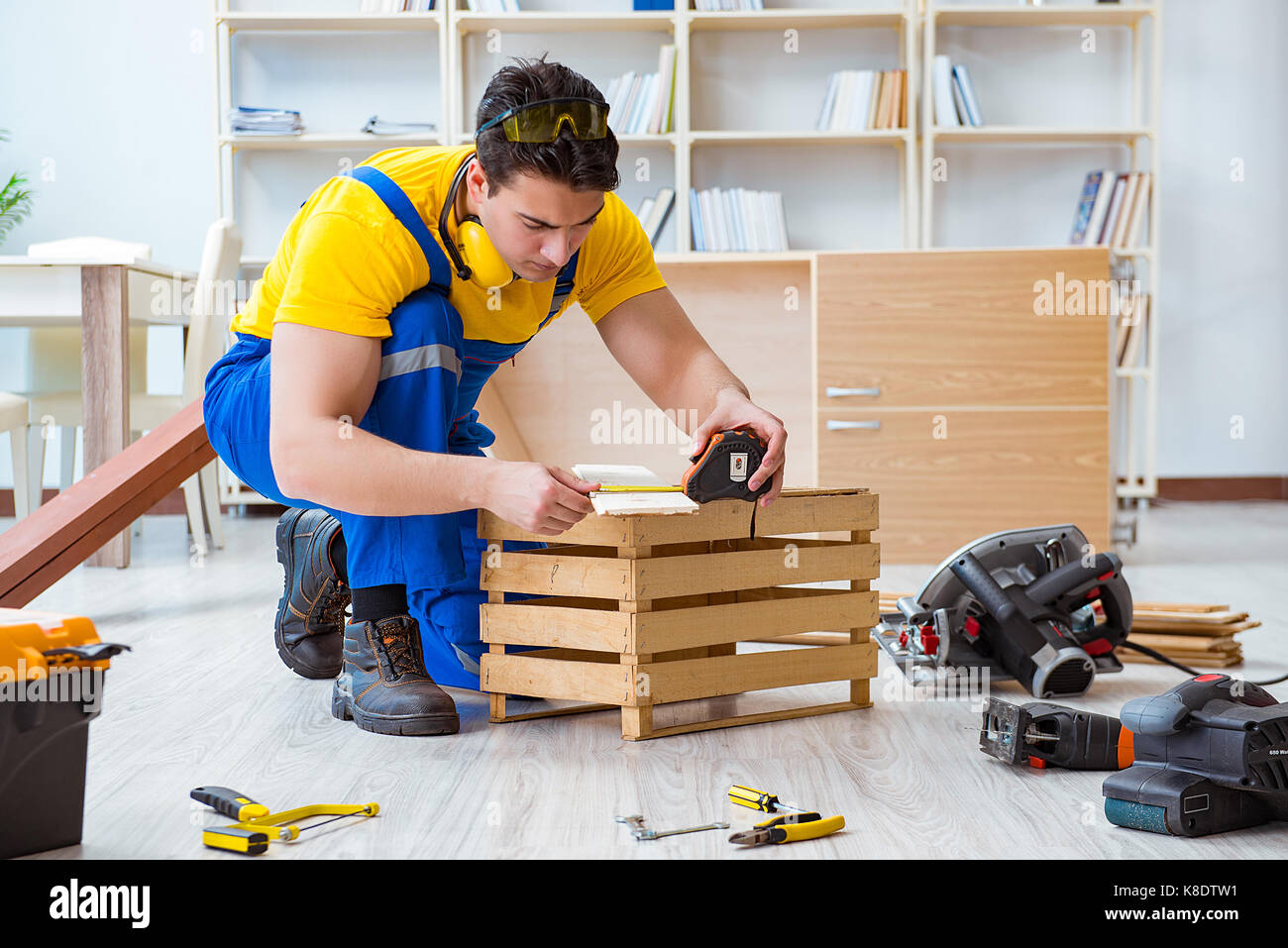 Repairman carpenter working with wooden board plank and measuring tape ...