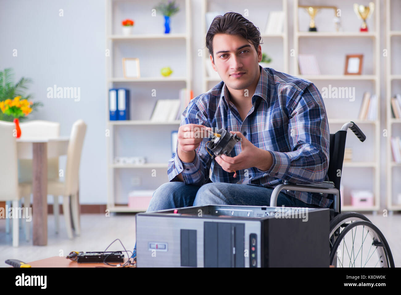 Disabled man on wheelchair repairing computer Stock Photo - Alamy