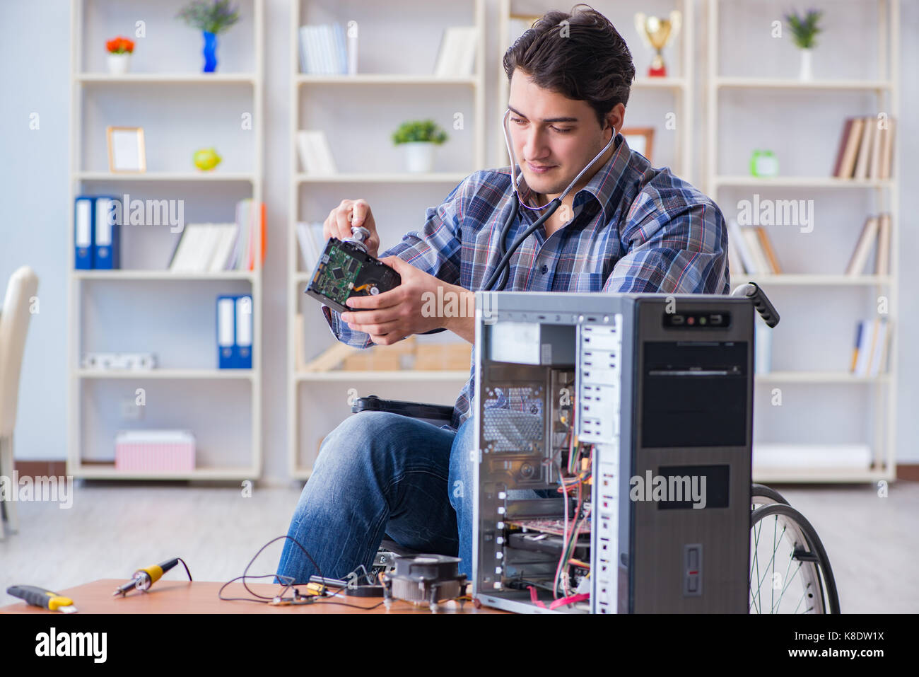 Computer repairman on wheelchair working Stock Photo - Alamy