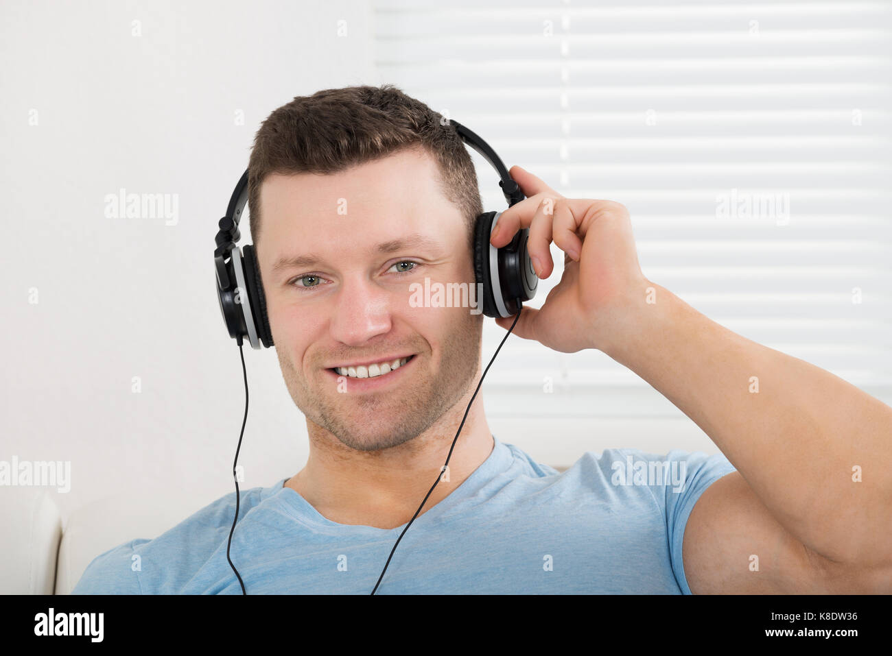 Portrait Of Smiling Mid Adult Man Listening To Music Through Headphones