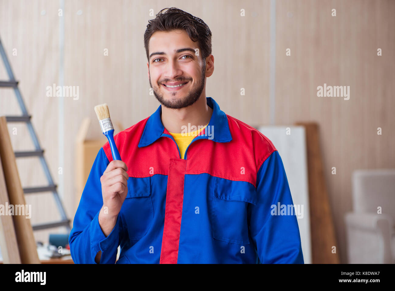 Yooung repairman carpenter working with paint painting Stock Photo - Alamy
