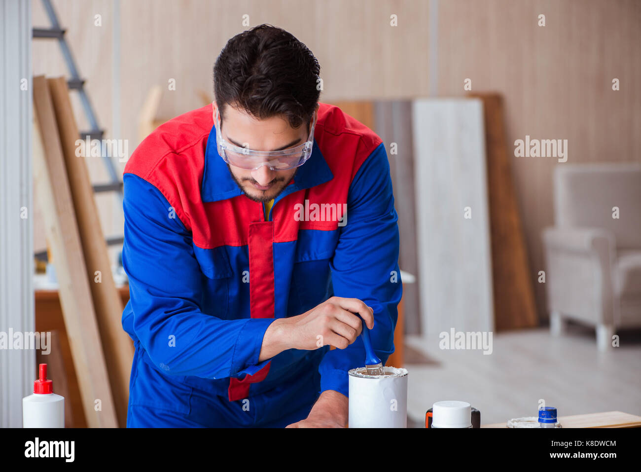 Yooung repairman carpenter working with paint painting Stock Photo - Alamy