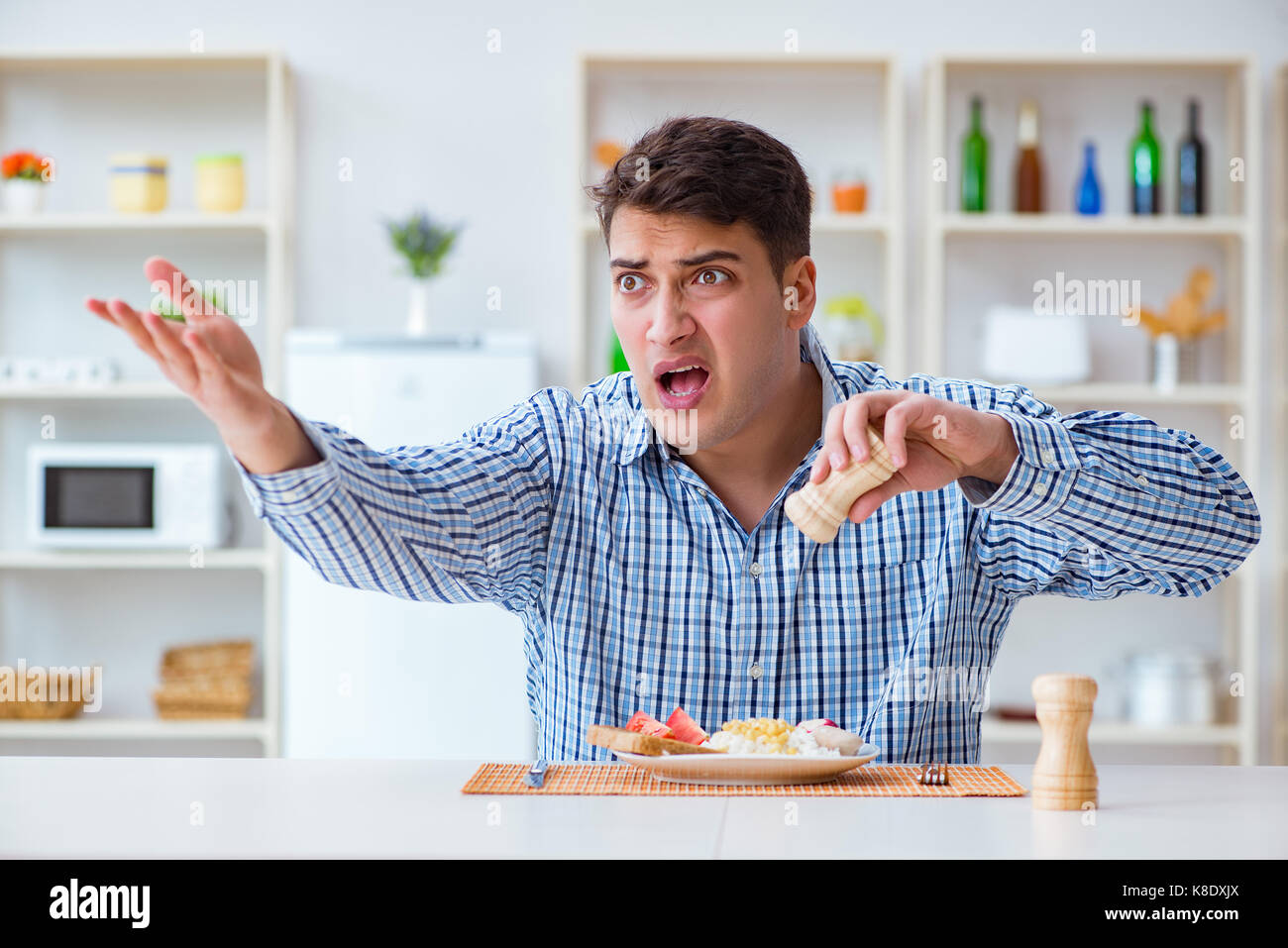 Young husband eating tasteless food at home for lunch Stock Photo - Alamy