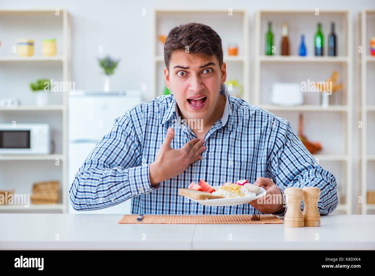 Young husband eating tasteless food at home for lunch Stock Photo - Alamy