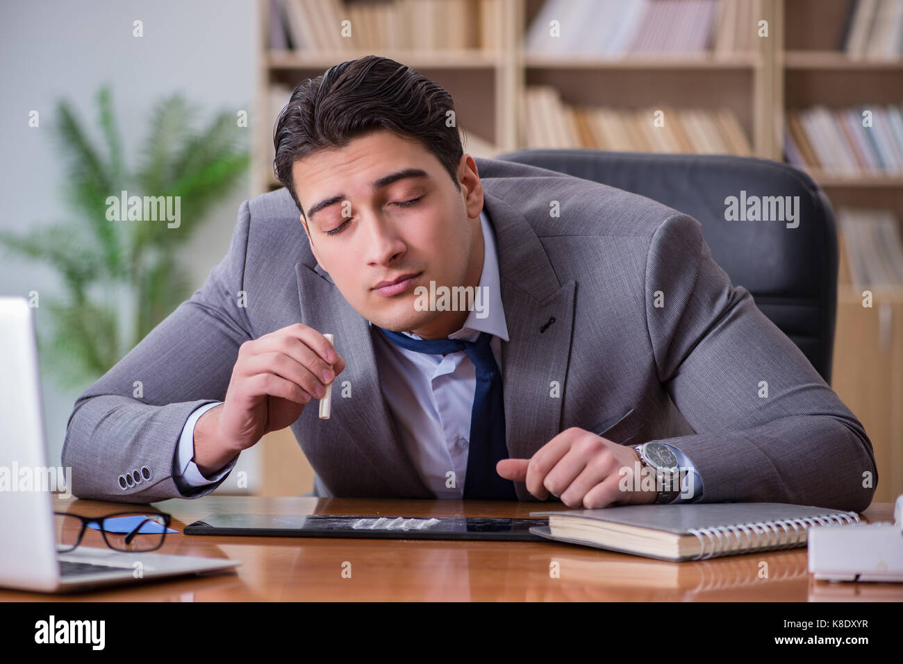 Drug addict businessman in the office Stock Photo - Alamy