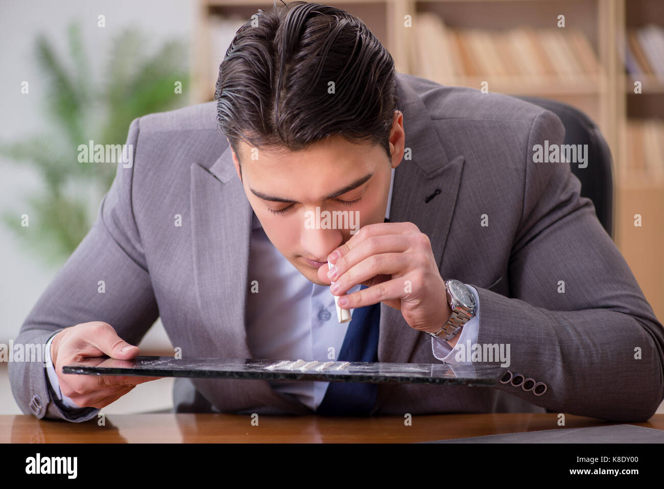 Drug addict businessman in the office Stock Photo - Alamy