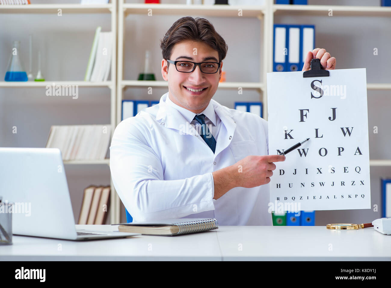 Doctor optician with letter chart conducting an eye test check Stock ...