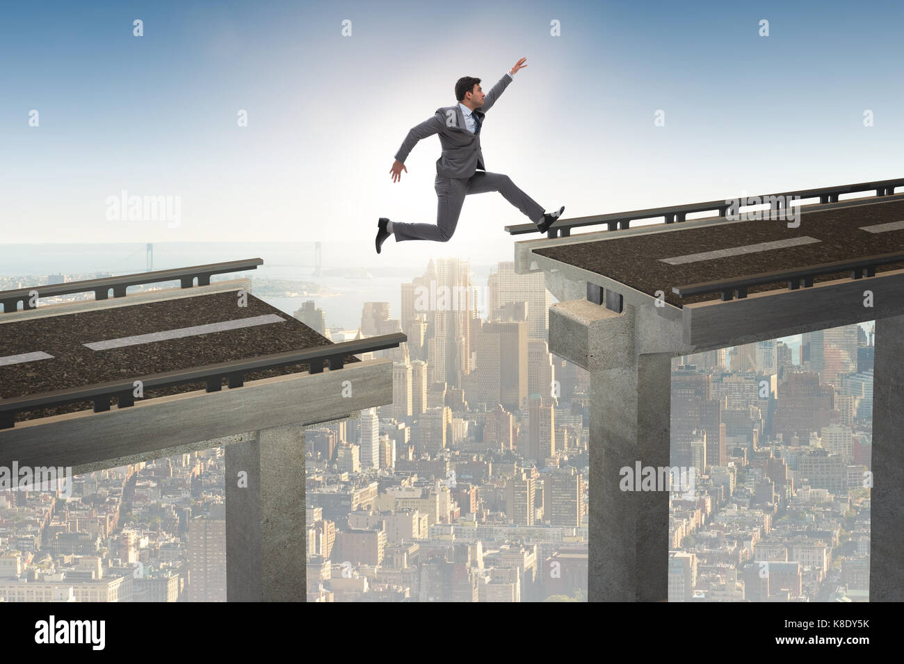 Young businessman jumping over the bridge Stock Photo - Alamy