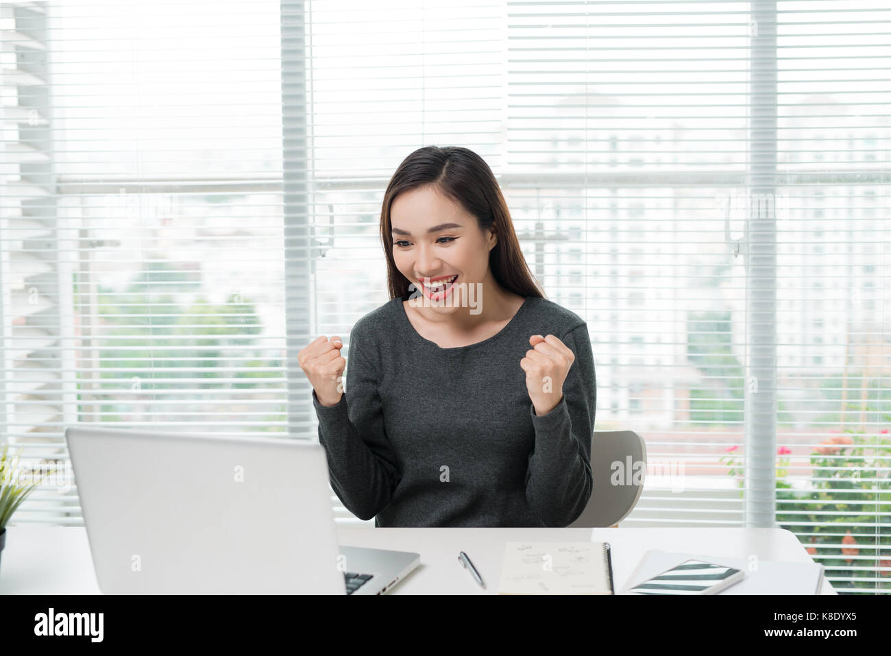Single young excited woman celebrating something with both arms ...