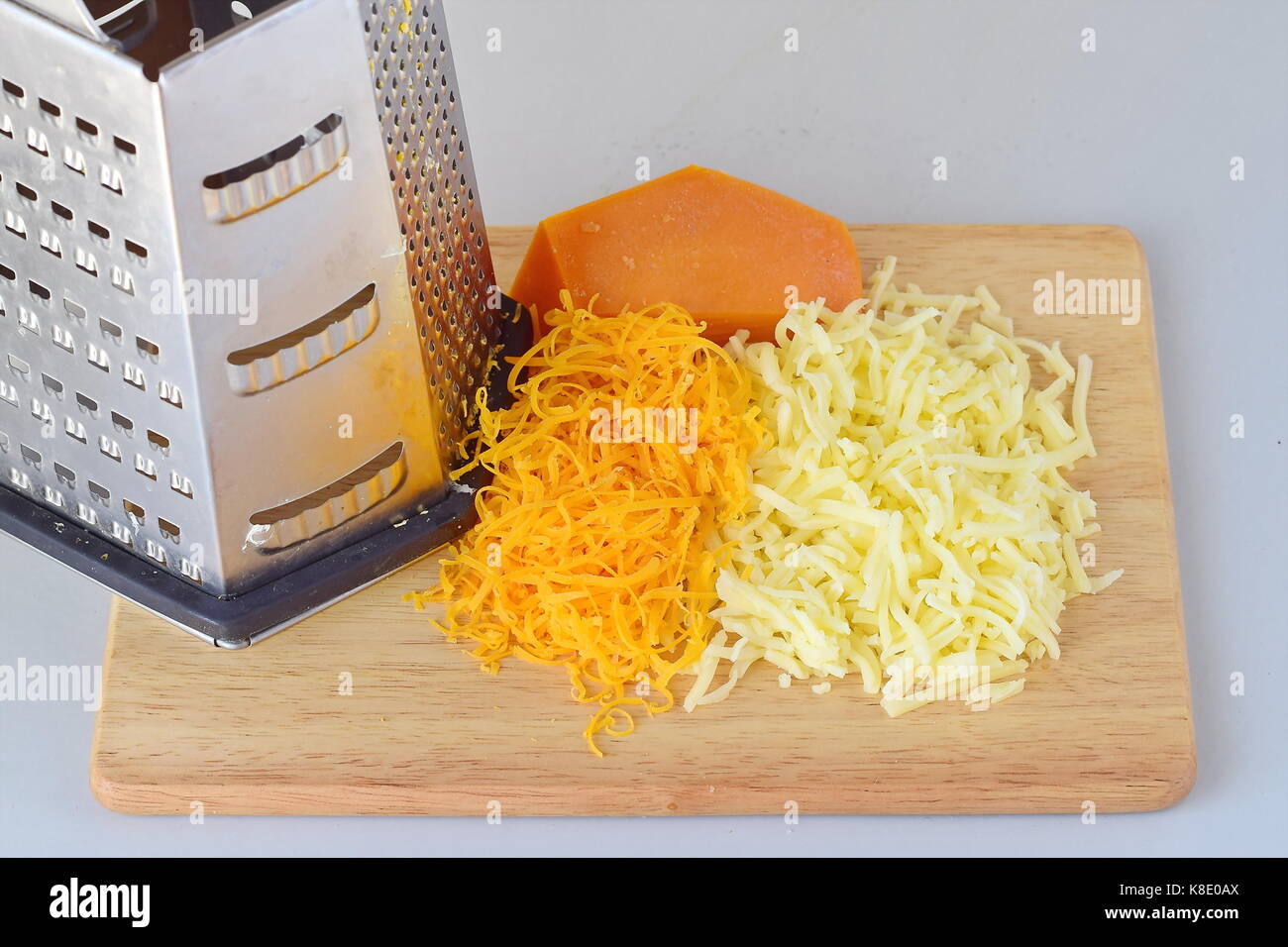 Step by step cooking. Grated gouda and cheddar cheeses with a grater on ...