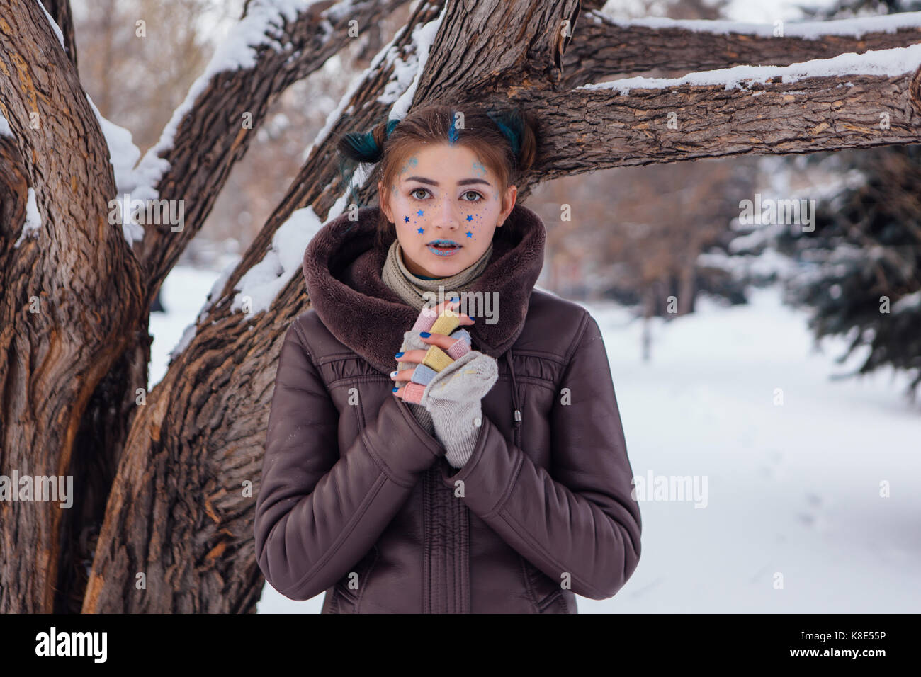 Winter portrait of a girl with bright make up and blue stars on face ...