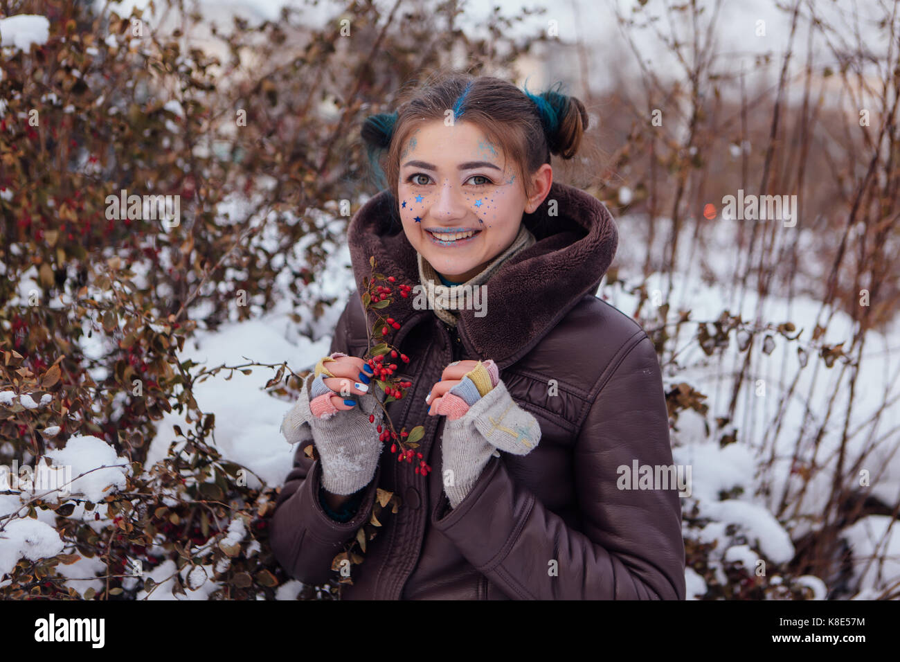 Winter portrait of a girl with bright make up and blue stars on face ...