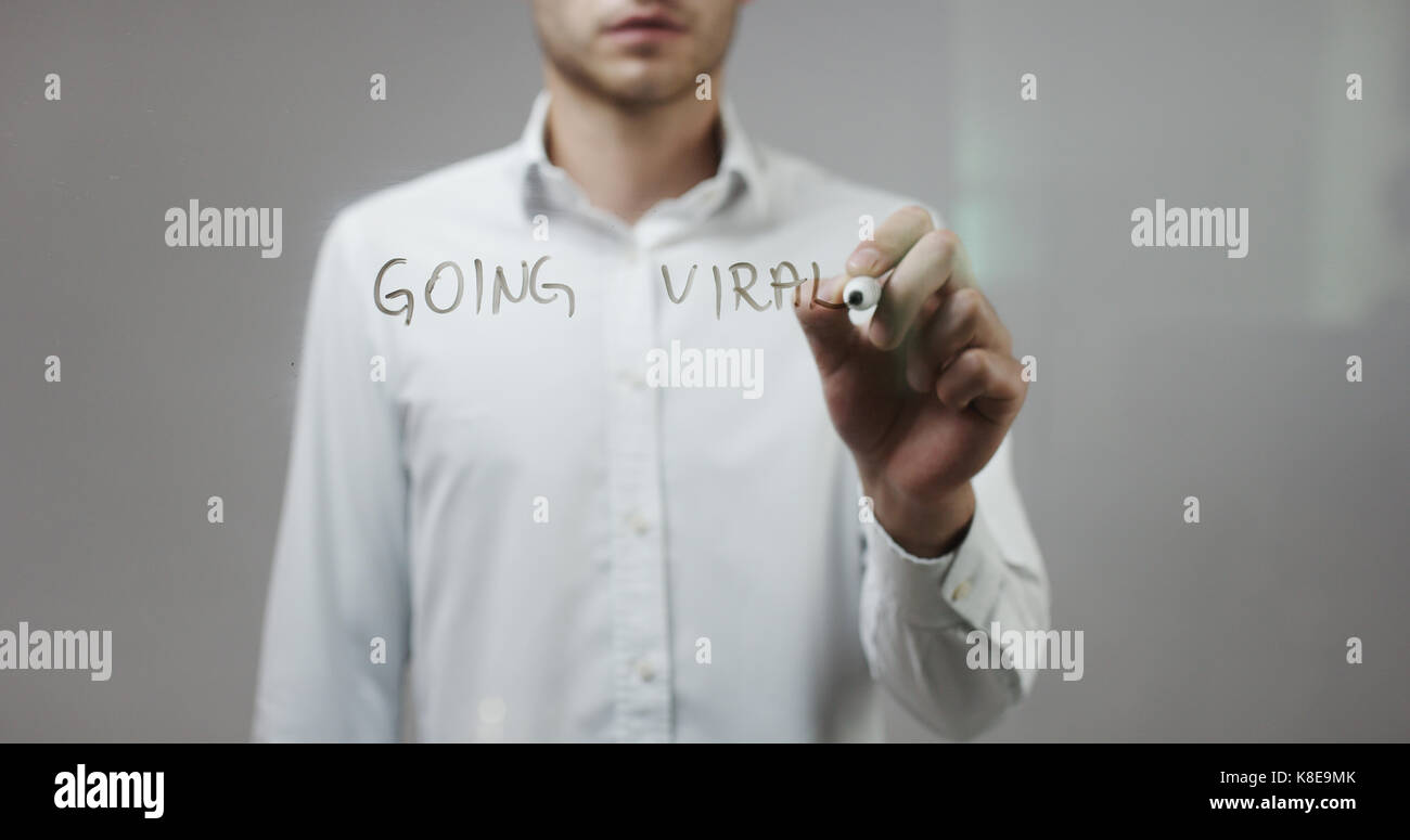 Going viral, Man Writing on Glass Stock Photo - Alamy