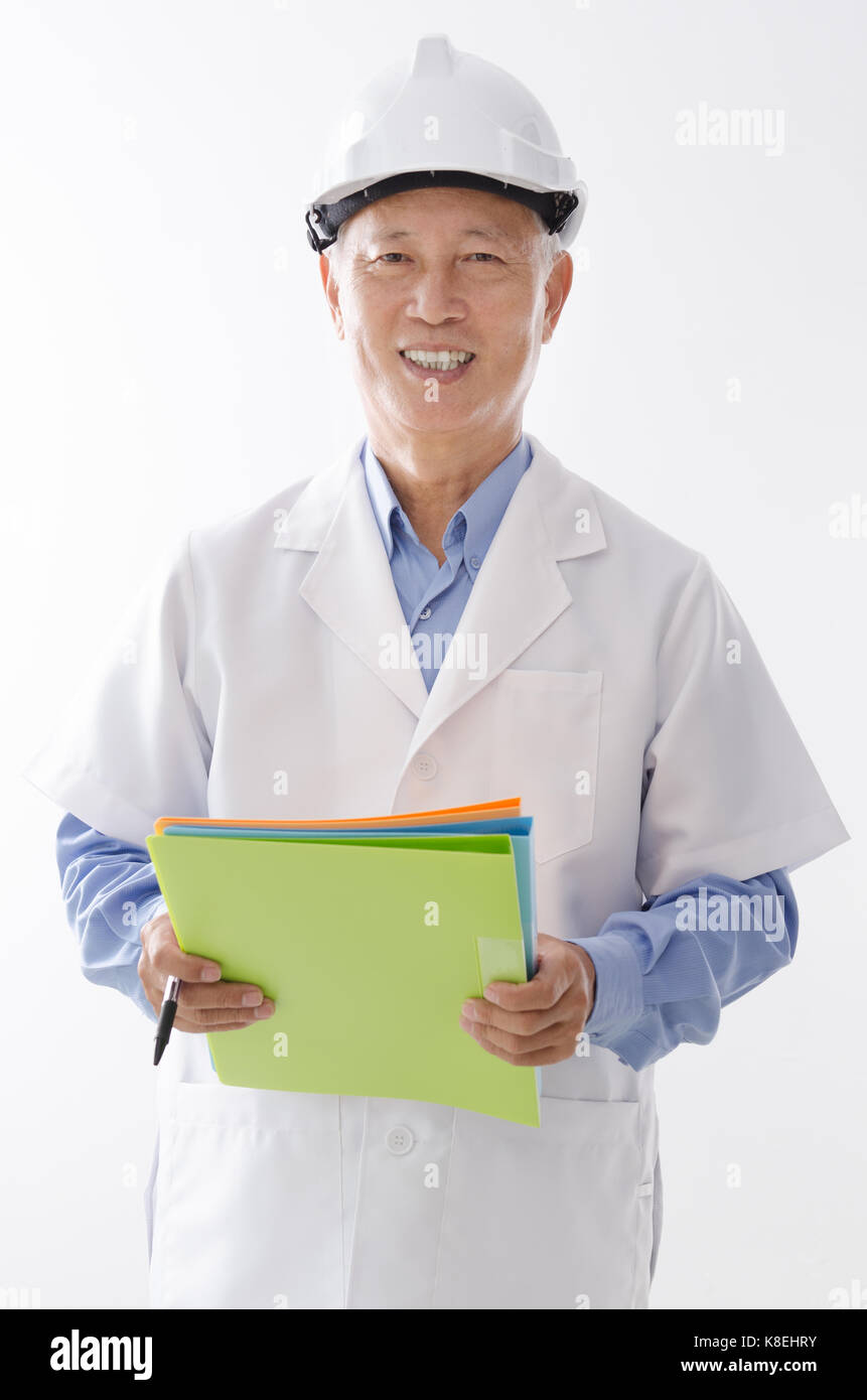 Portrait of old Asian engineer in uniform with hard hat, standing ...