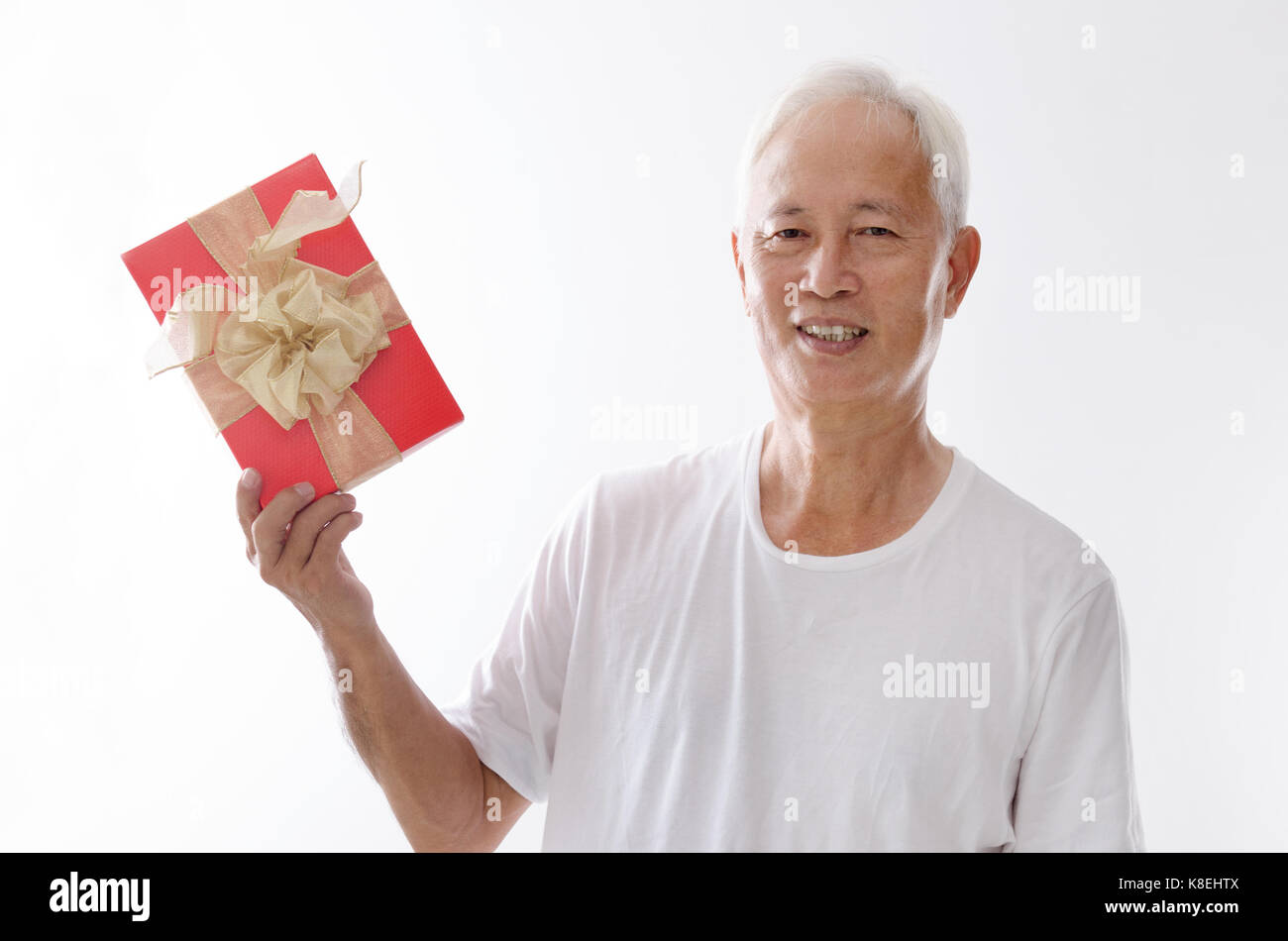Portrait of old Asian man hand holding a gift box, isolated on white ...