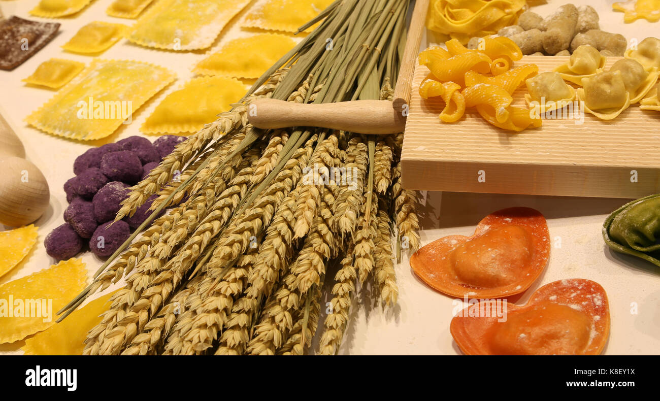 fresh pasta in a specialized Italian food store and ears of ripe wheat ...