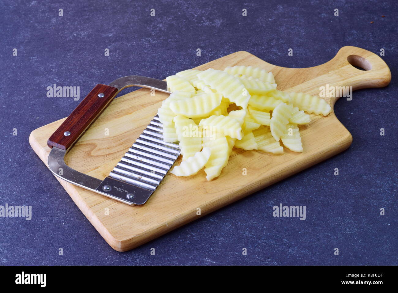 Potato peeled and cut in pieces with a special knife with ribs on a ...