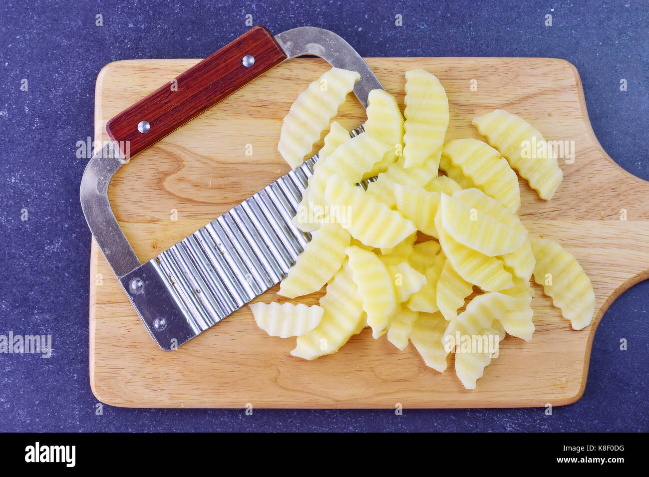 Potato peeled and cut in pieces with a special knife with ribs on a ...