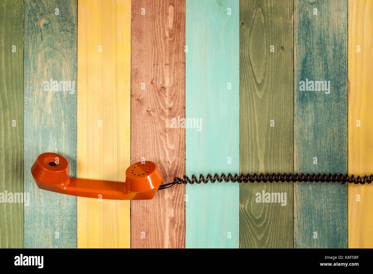 Vintage telephone receiver on wooden background, top view, pick up the ...