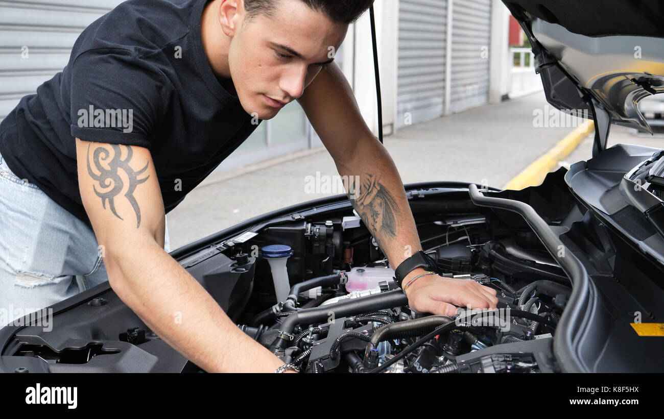Handsome young man trying to repair a car engine Stock Photo - Alamy