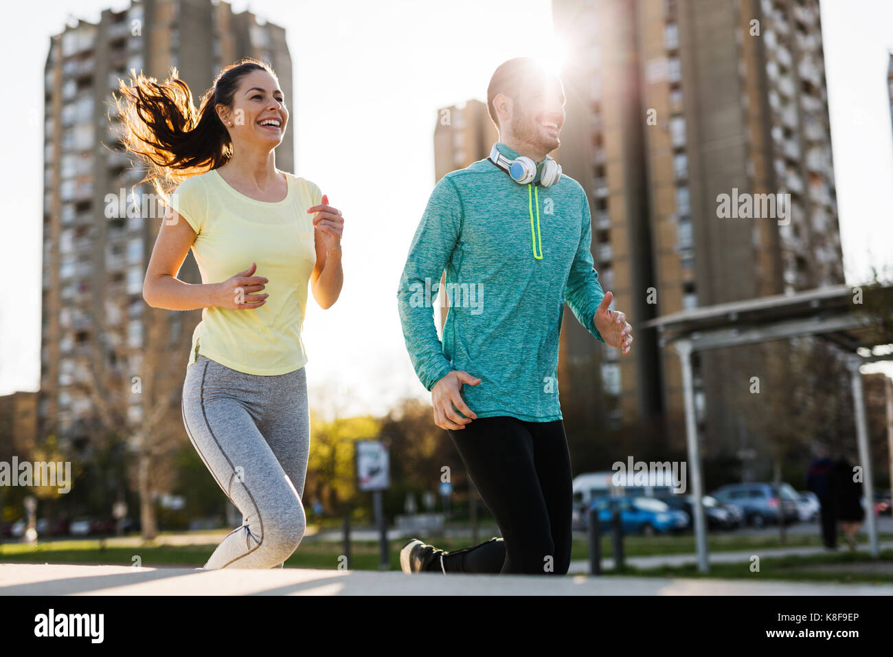 Young attractive couple running outside on sunny day Stock Photo - Alamy